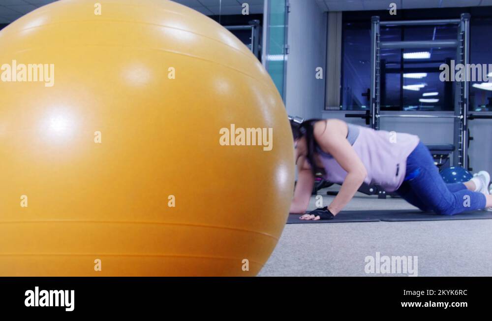 Training. A young woman pumping her hand muscles leaning on the floor ...