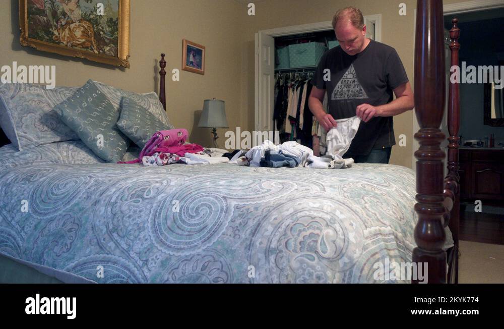 Dad folding clothes on bed in bedroom house chores Stock Video Footage ...