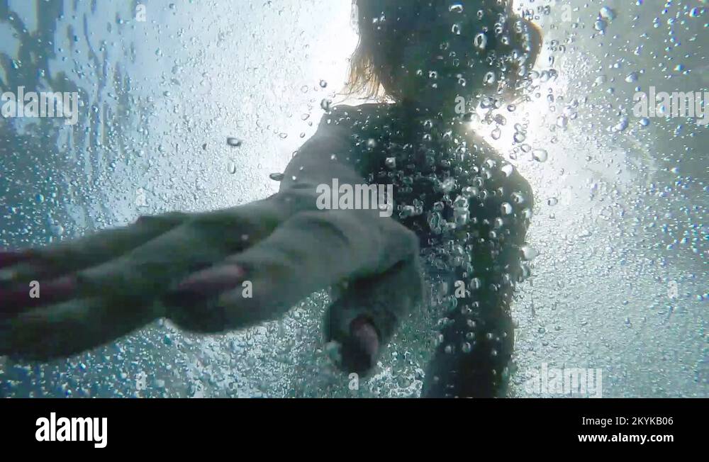 Pretty young woman diving underwater with Go-pro camera in swimming ...
