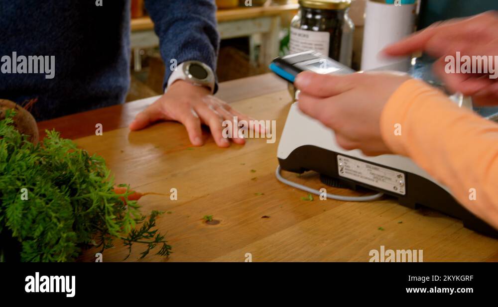 Mid section of customer making payment at counter in supermarket 4k ...