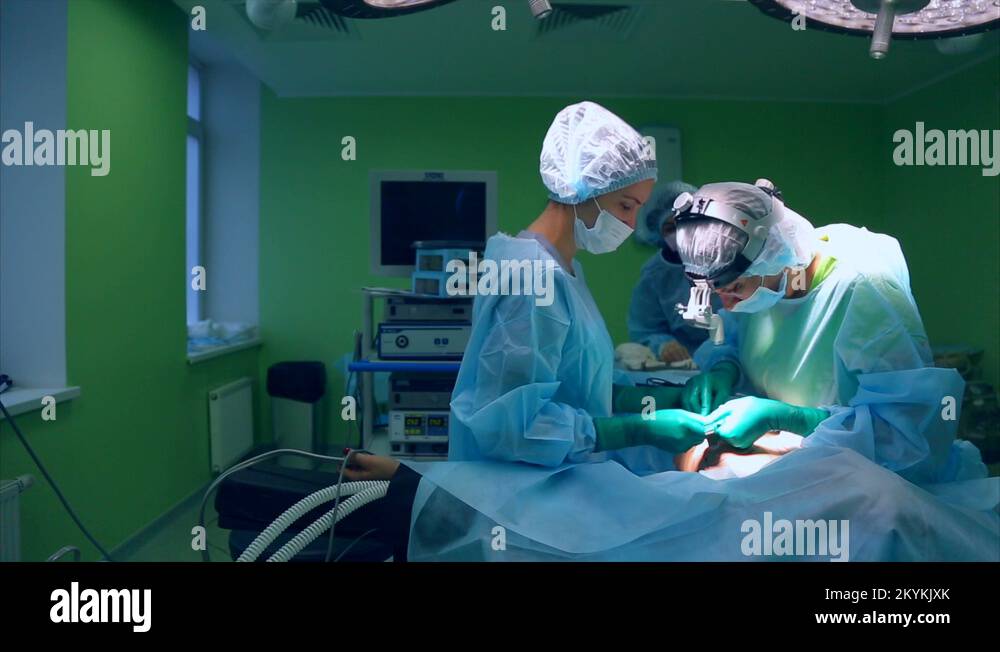 Surgeon and surgical team are performing cosmetic surgery on breasts in ...