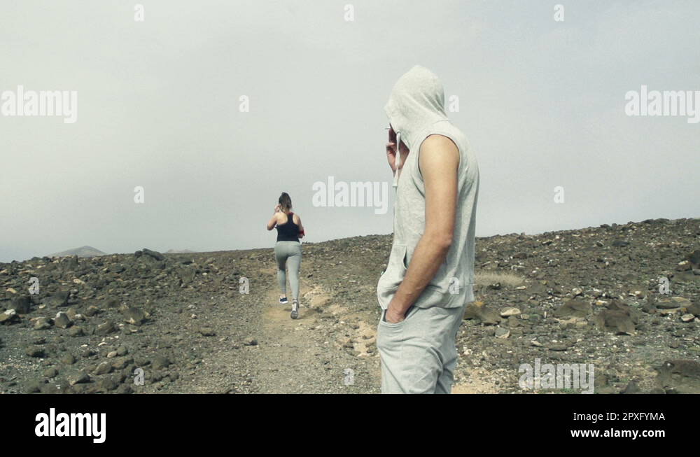 Man smoking cigarette and woman jogging on desert HD Stock Video ...