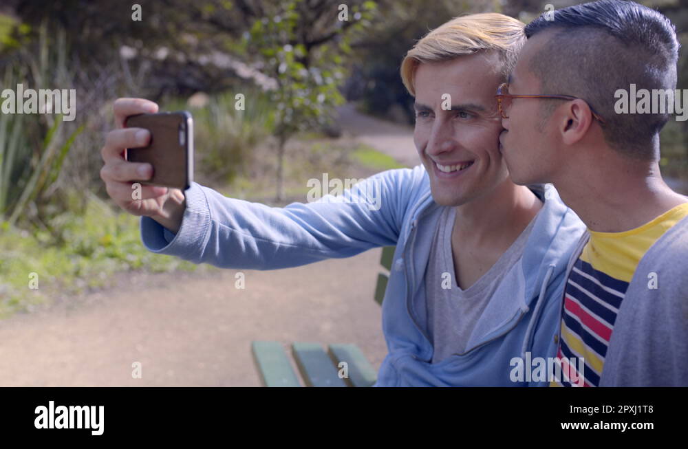 Cute Gay Couple Pose/Kiss On Cheek For A Selfie Together On A Park ...