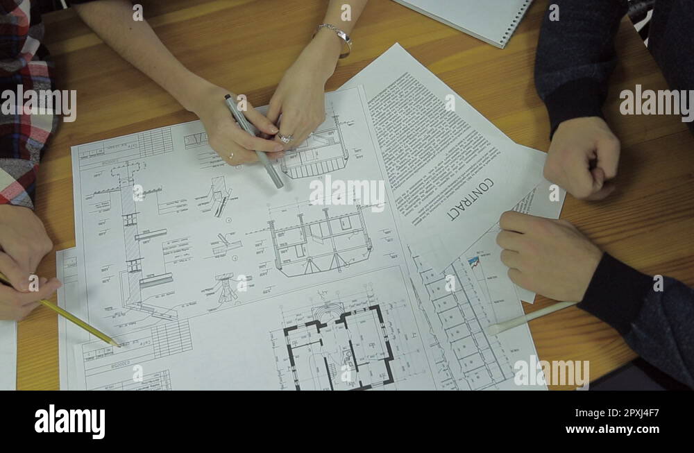 Group of Architects Planning on a New Project with their Blueprint ...