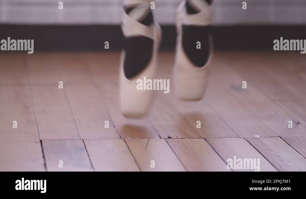 Close up of a ballet dancer's feet as she jumps and changes positions ...