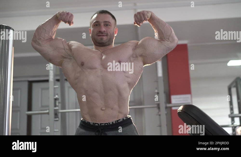 The world champion of bodybuilding posing in the gym. Slowly Stock ...