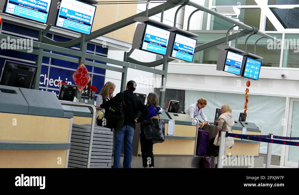 Passengers with luggage at Air Canada check in counter inside YVR airport Stock Video Footage ...