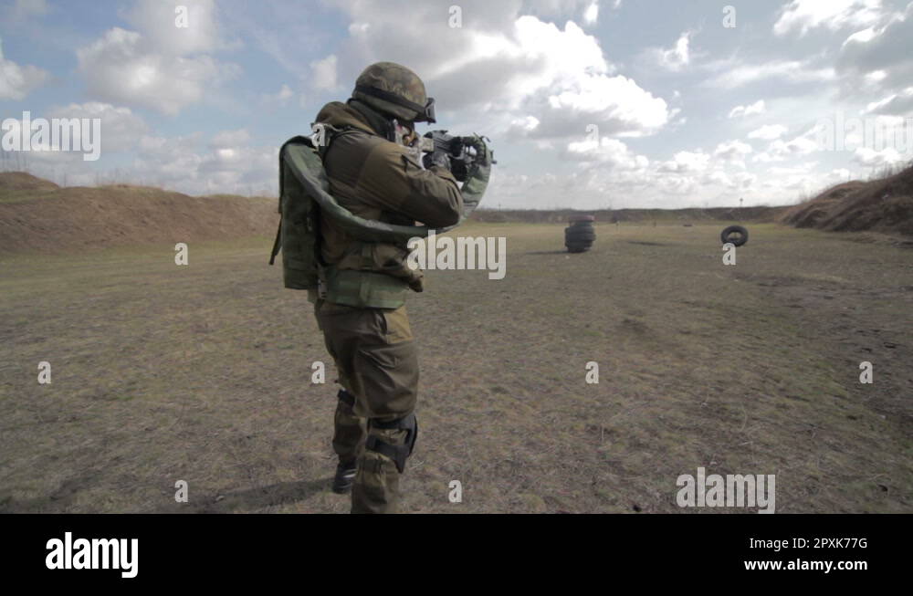 A soldier with a machine gun on a military firing range shooting at a ...