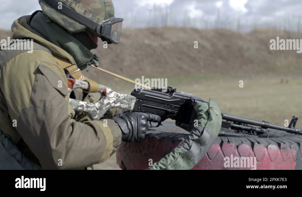 A soldier with a machine gun on a military firing range shooting at a ...
