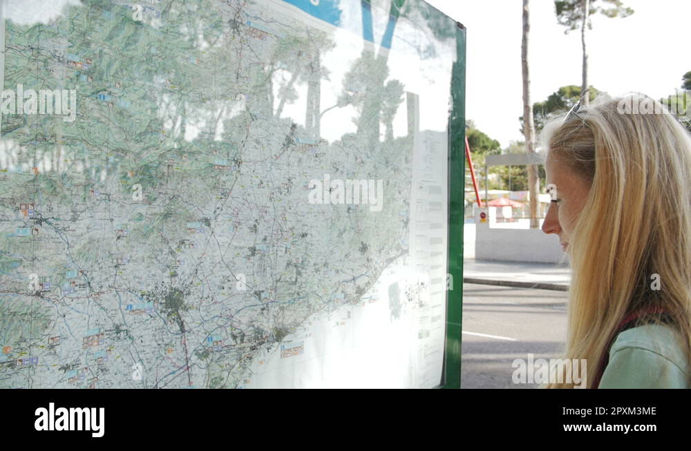 Tourist woman looking at map. Side view of female person lost in city ...