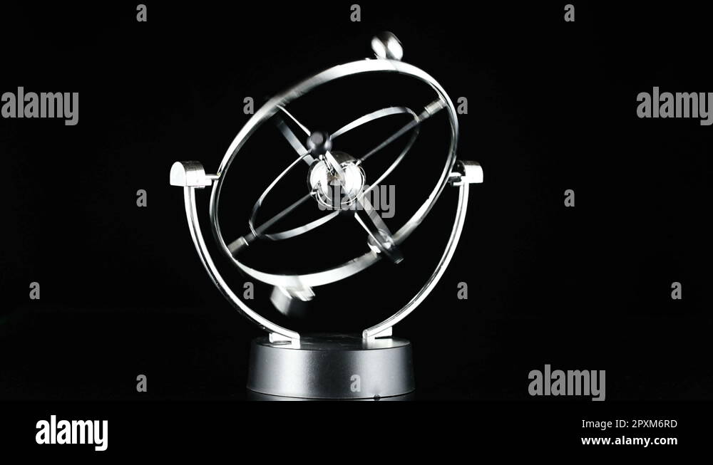 Close up of Newton's Cradle, Desk toy pendulum being activated, black ...