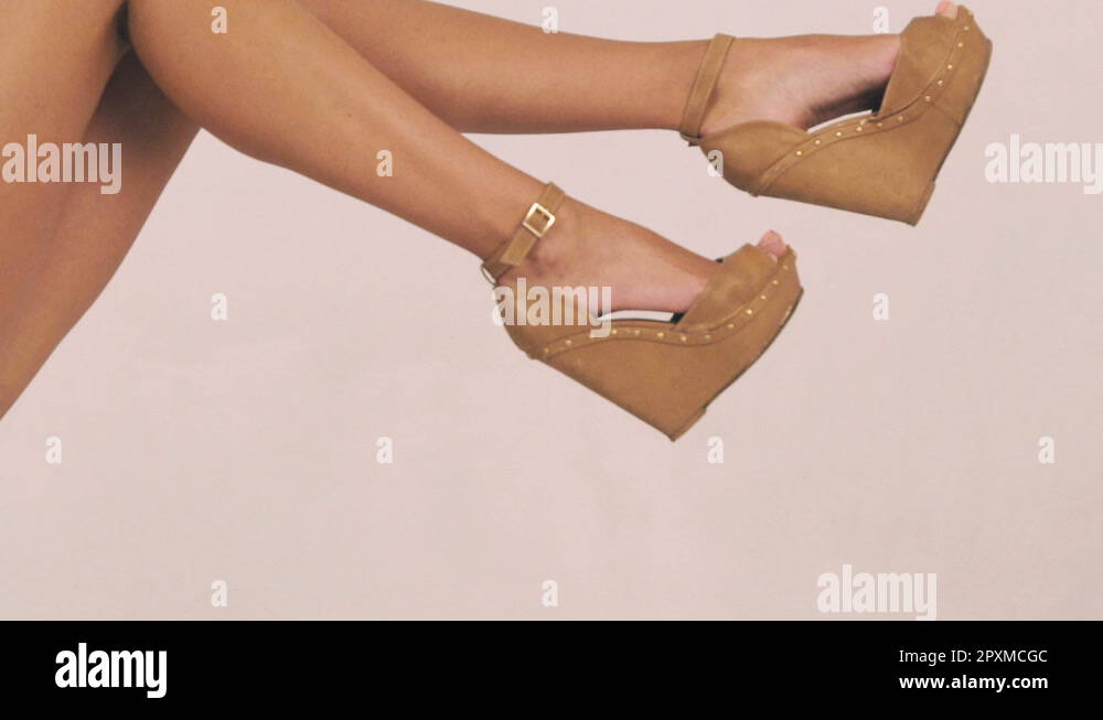 Girl's legs in heels moving in air on white background . Slow motion ...