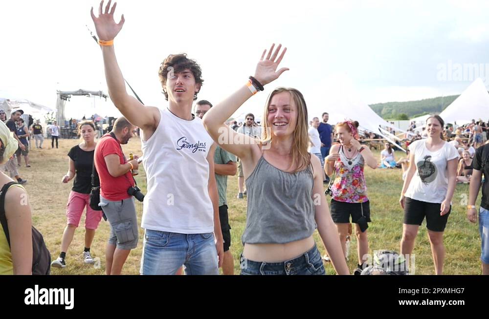 Cute guys spectators fans jump dancing enjoying free open air music ...