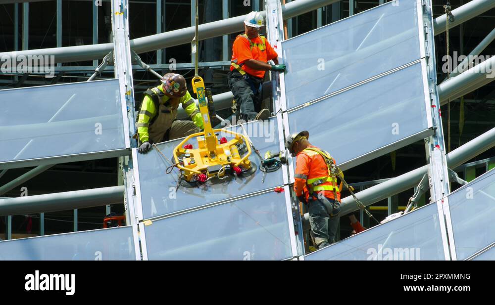 Construction workers install glass windows at development site, 4K, RAW ...
