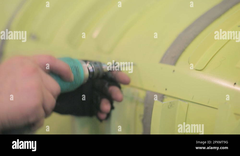 Employee aircraft manufacturing plant drills holes in fuselage of ...