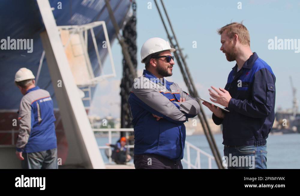 two engineers with laptop smile and communicate in Shipping cargo port ...