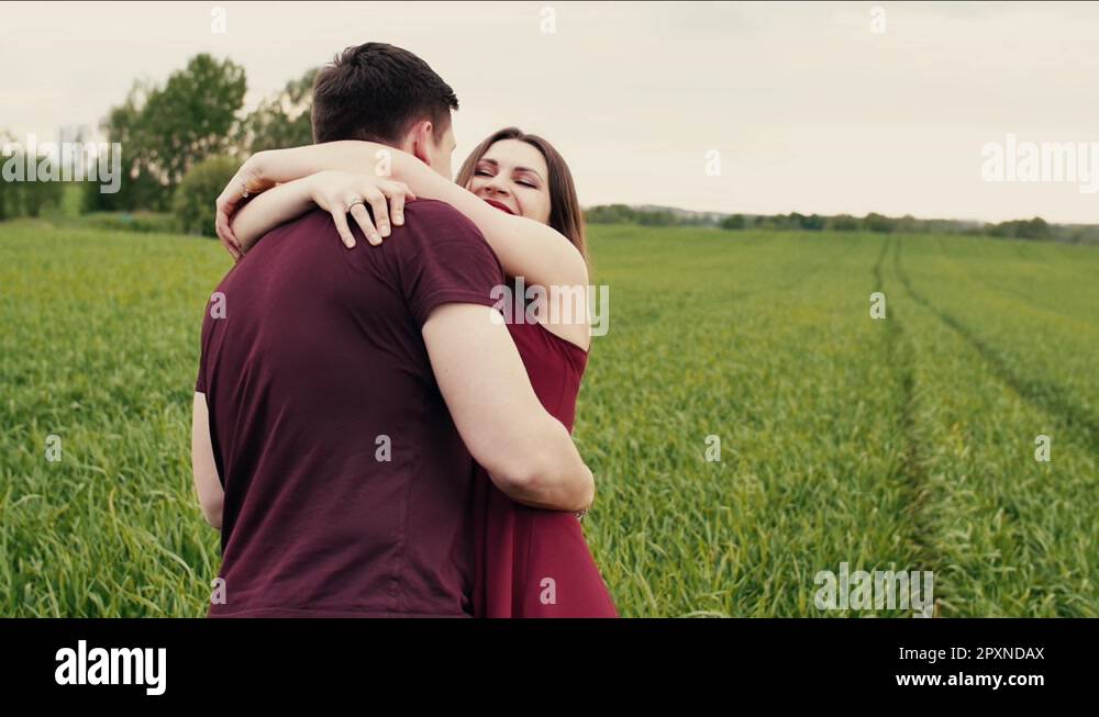 A romantic couple whirling around, kissing, laughing and having fun ...