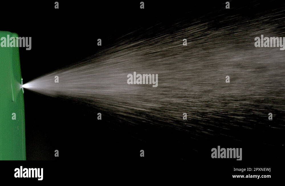 Aerosol Can spraying fine white Mist into Air against black background ...