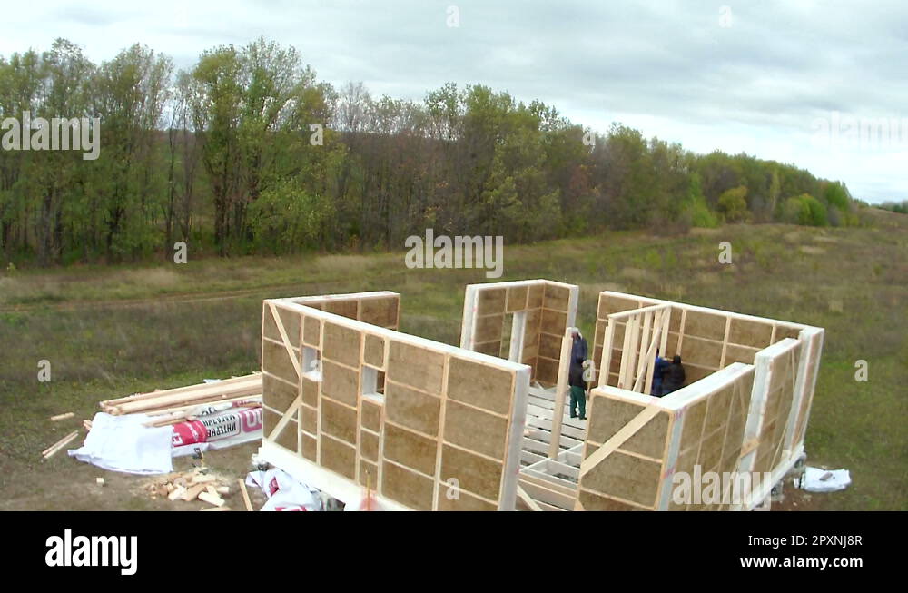 Country house of straw bales construction. workers make interior walls ...