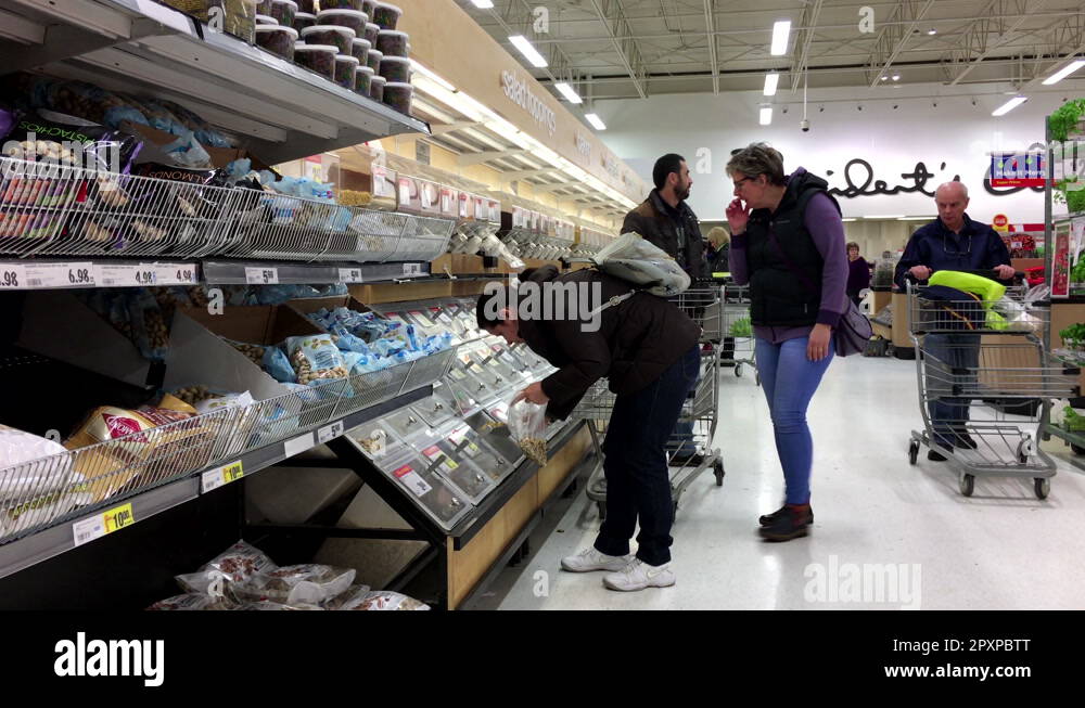 Motion of people picking fod at bulk foods section inside superstore ...