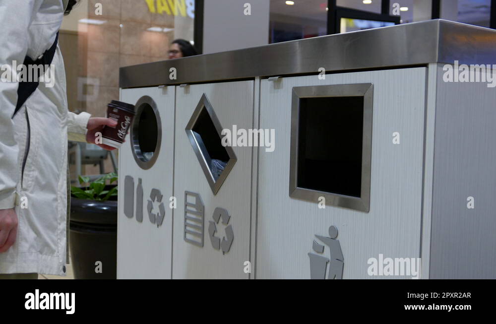 Woman throwing trash to the garbage can inside shopping mall Stock ...