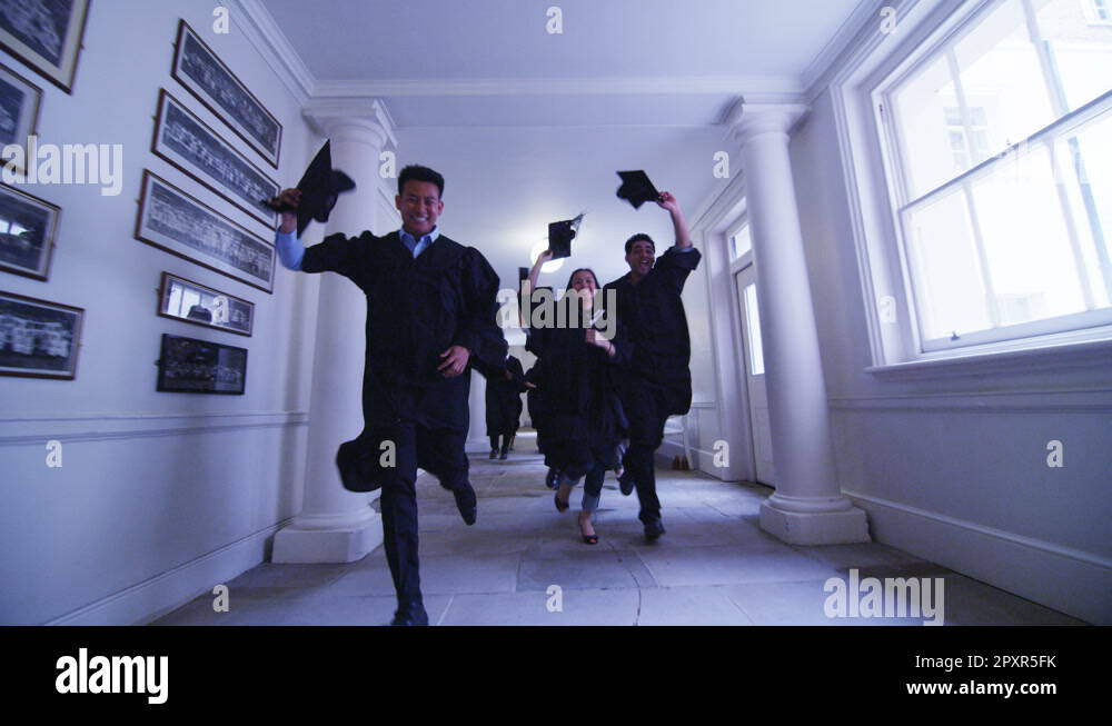 4K Students on graduation day running through hallway of university ...