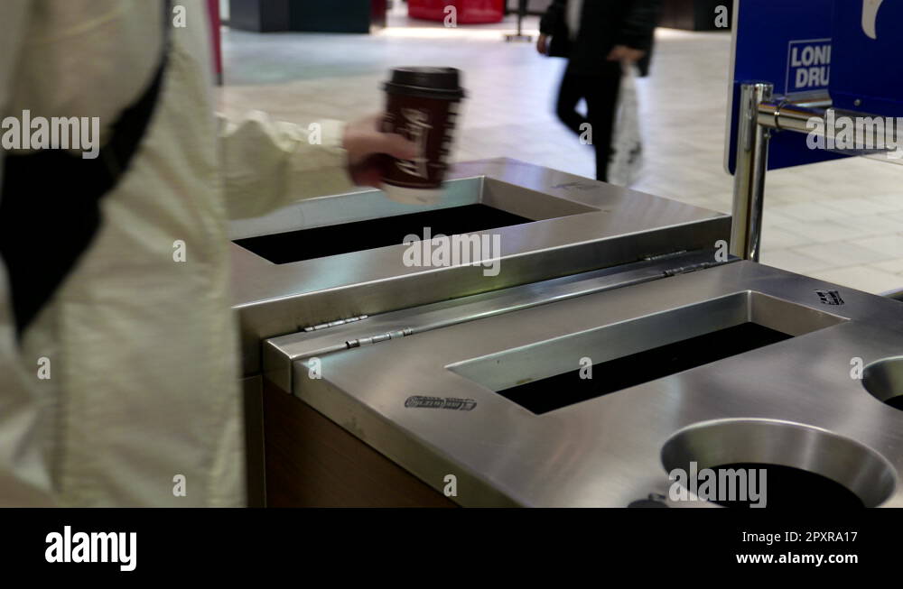 Woman throwing trash to the garbage can inside shopping mall Stock ...