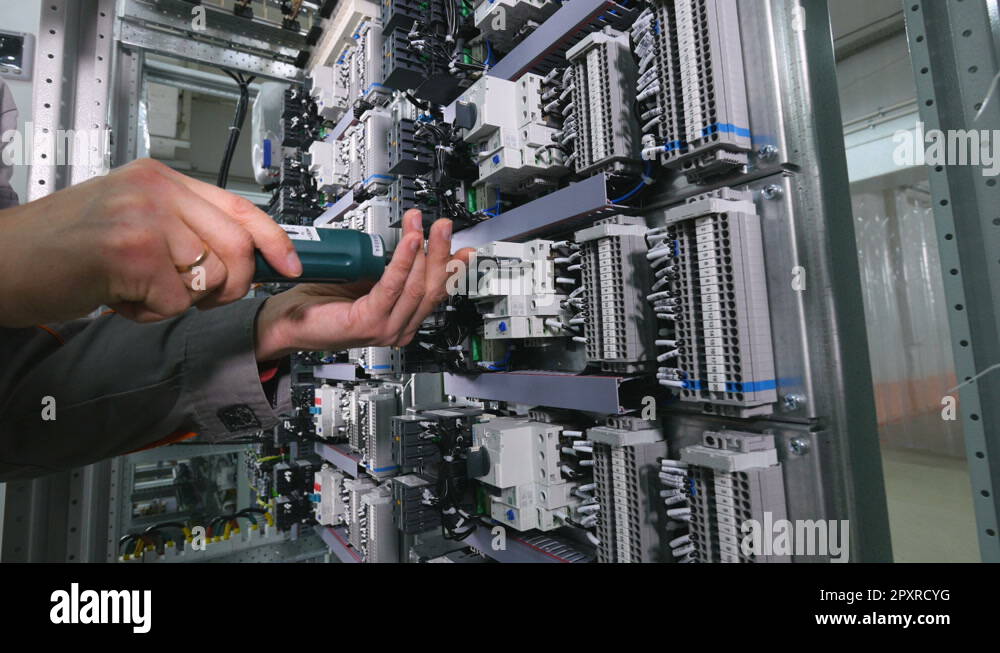 Electircian installing circuit breakers in electrical fuse box at the ...