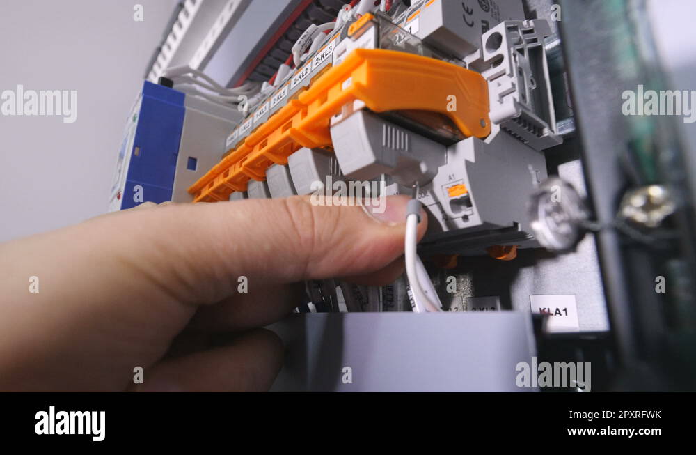 Electrician installing wires, cables into a electricity power shield ...