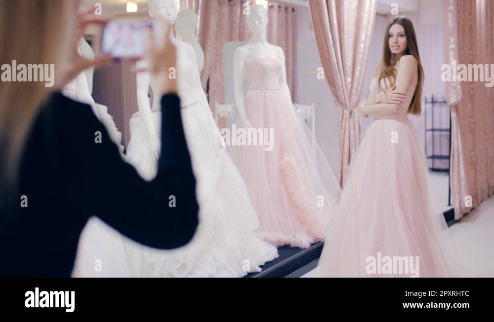 Pretty girl trying on prom gown in fitting room Stock Video Footage - Alamy