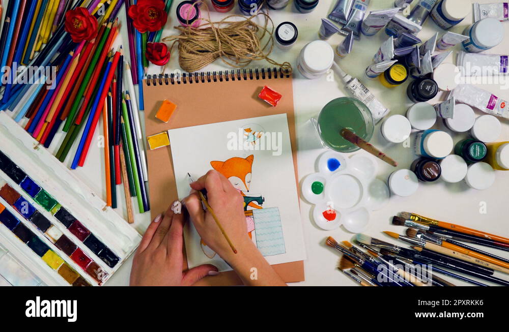 Hands drawing using watercolors, art tools. Artist desk from above. Top ...