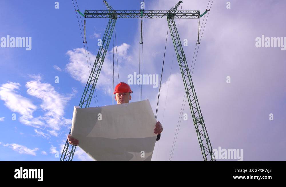 Electrical engineer with a plan of electric grids in the hands near ...
