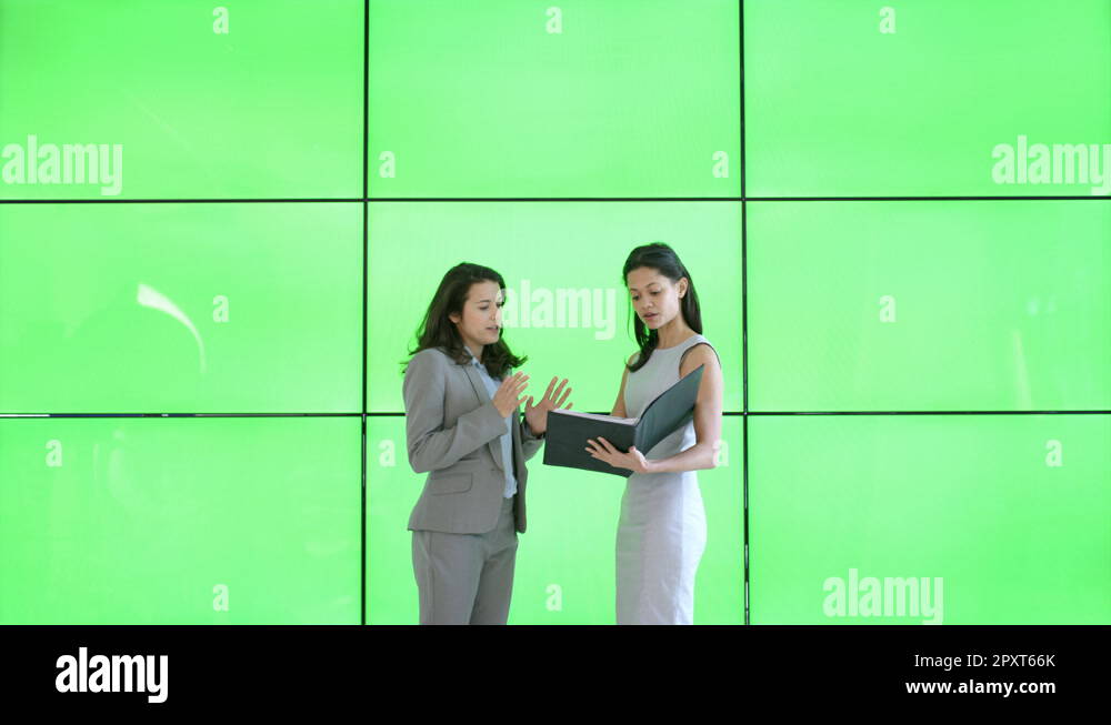 4K Businesswomen in discussion in modern office with green screen ...