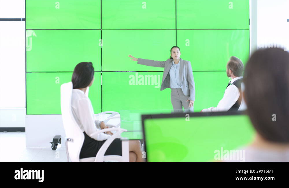 4K Business team in a meeting, interacting with large green screen ...