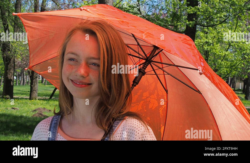 A teenage girl with an umbrella. Girl with freckles in the park Stock ...