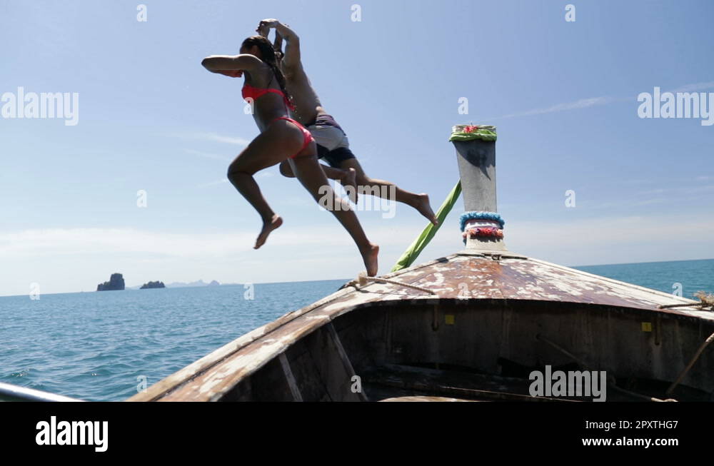 Couple Jumping In Water From Long Tail Boat Nose, Young Man And Woman ...
