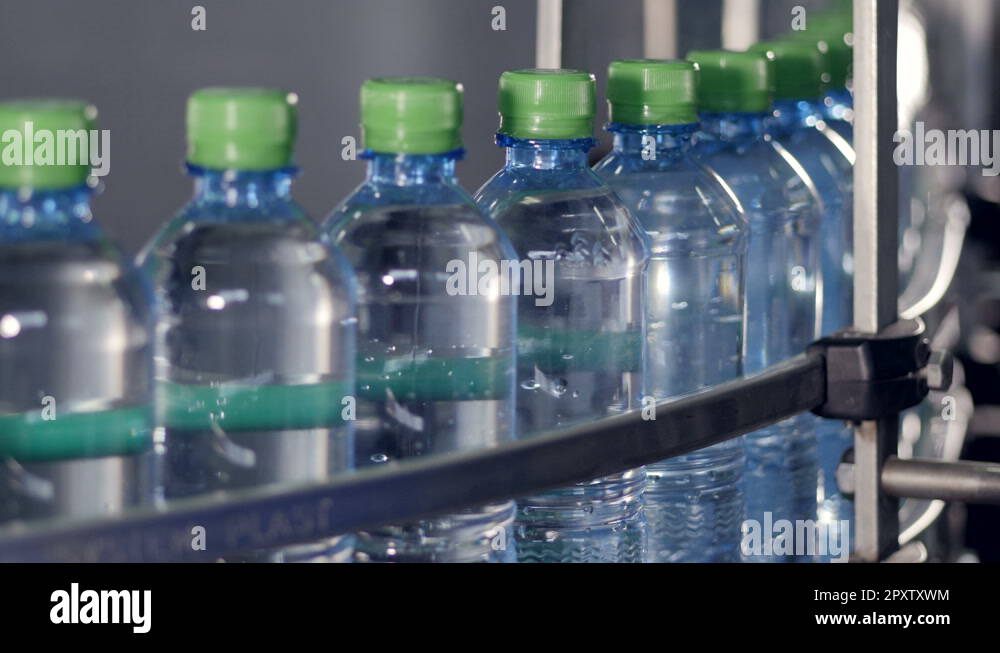 Capped bottles filled with water moving on a conveyor Stock Video ...