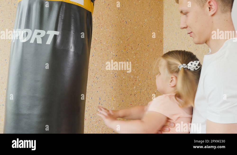 Father holds a little daughter on hands and cute girl is beating by the ...