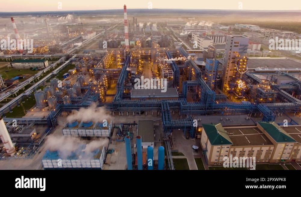 A huge oil refinery with metal structures, pipes and distillation of ...