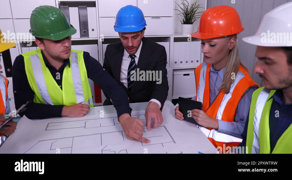 Busy Engineers Group Collaborating Examining Digital Blueprint Plan in ...