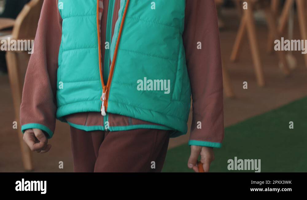 Preteen girl standing on podium showing winter clothes at kids fashion ...