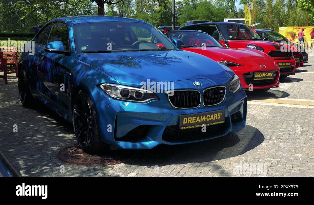 BMW M2 modern blue car on autoshow with other cars in the background ...
