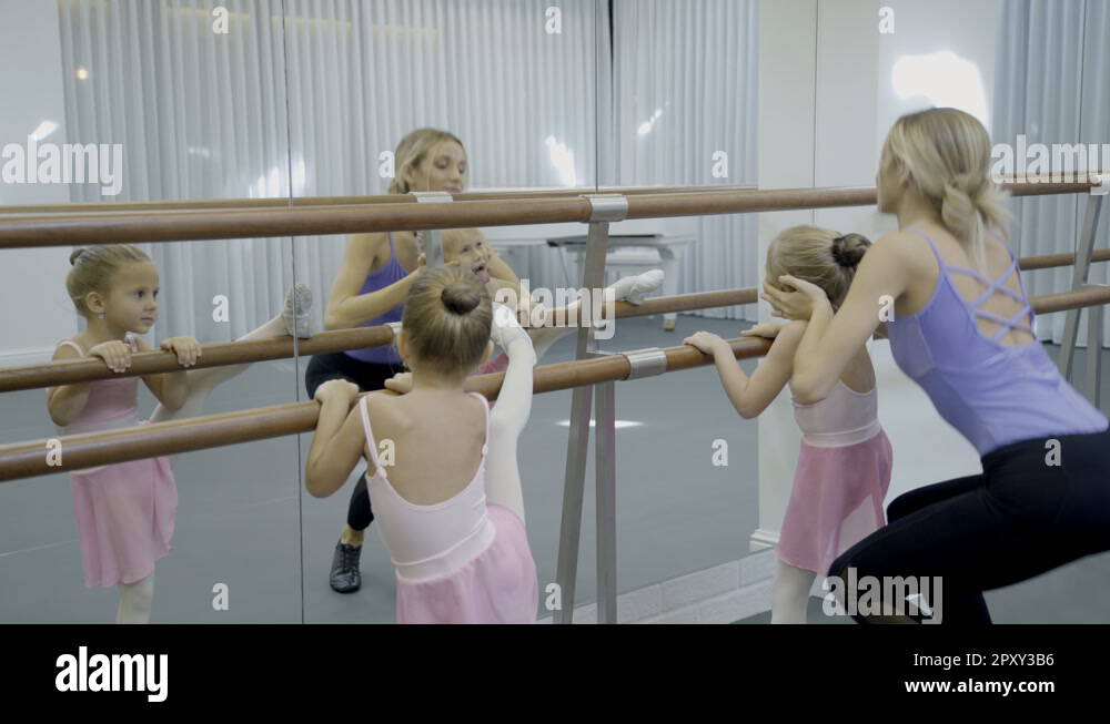 Teacher near ballet shows young children dance position Stock Video ...