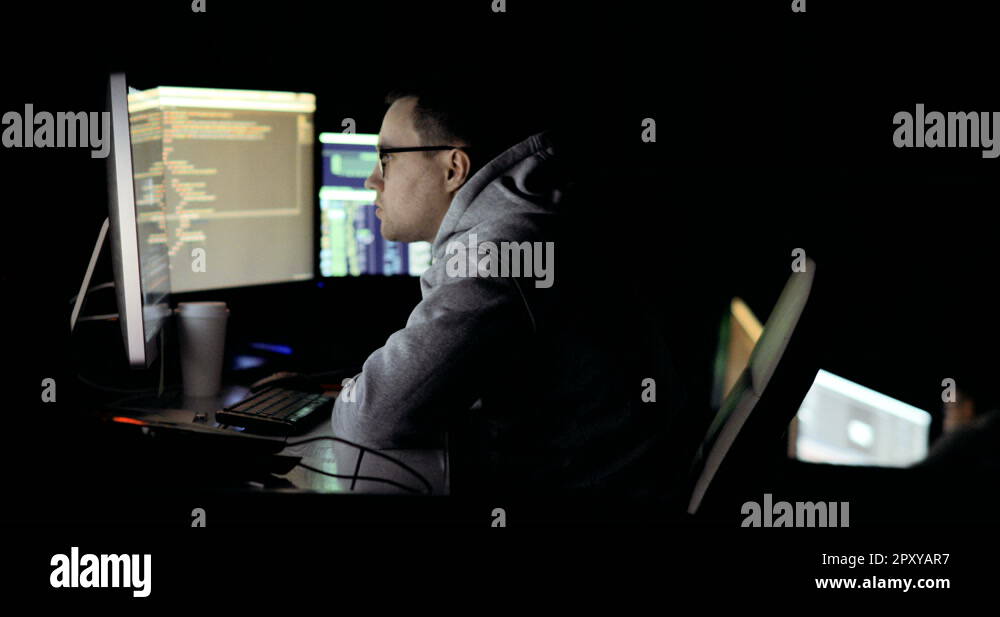 Hacker in hood cracking code using laptop and computers from his dark hacker Stock Video Footage ...