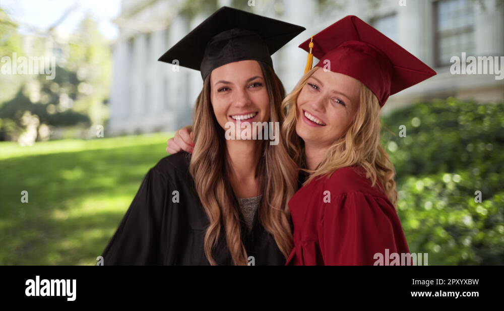 Two pretty college graduates pose happily while getting ready for their ...