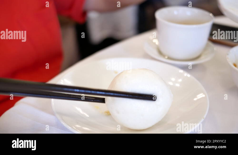 Motion of people eating steamed egg yolk bun inside Chinese restaurant ...