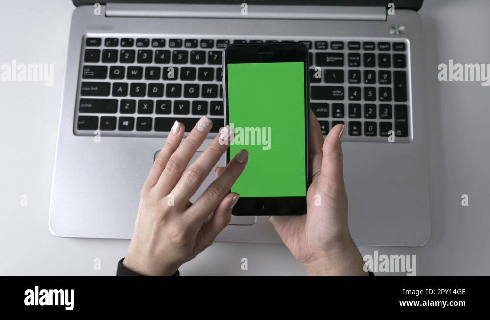 Female hands scrolling on the smartphone's touchscreen. Green screen ...