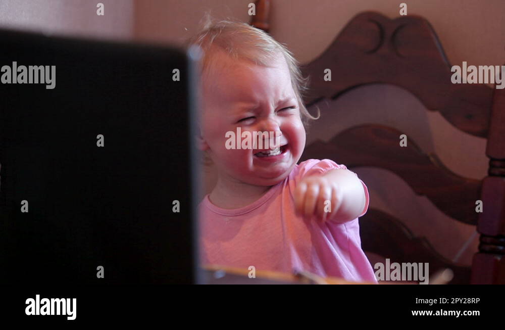 Baby cries in front of laptop screen, after the cartoon ended Stock ...