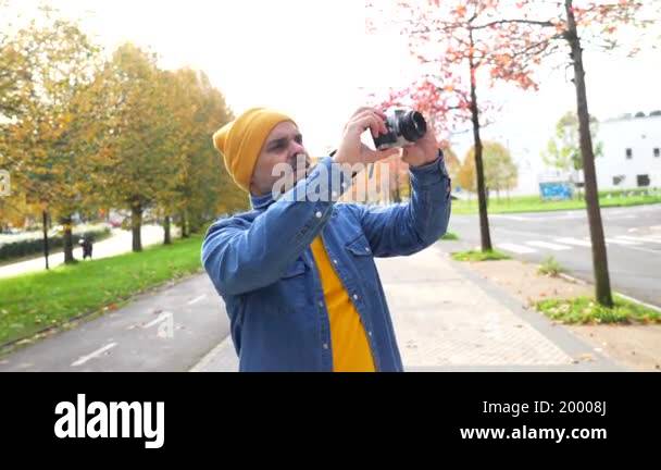 Photographer is composing shots in an urban park setting, bringing the ...