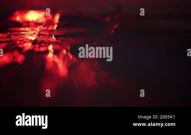 The image is a blurry, red and orange shot of a rocky shoreline. The ...